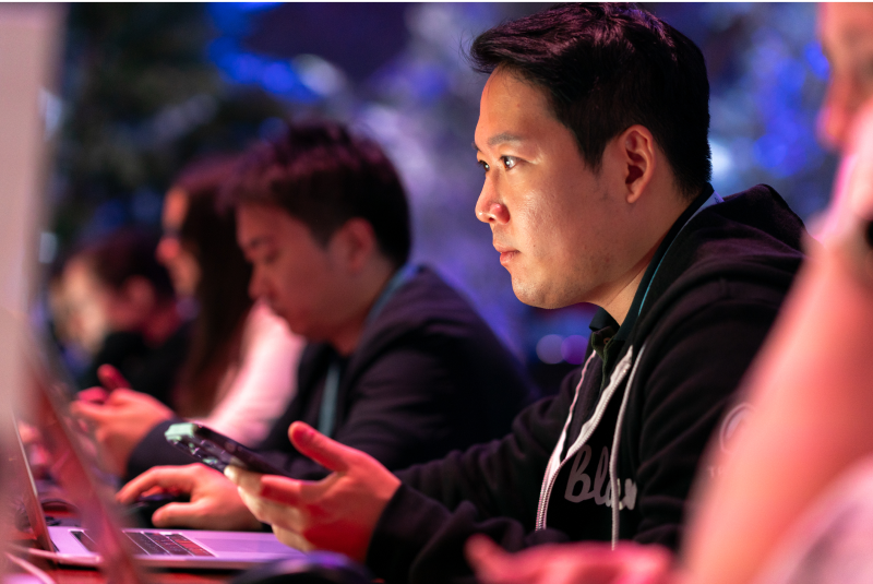 Side profile of a man holding a mobile phone while looking intently at ...